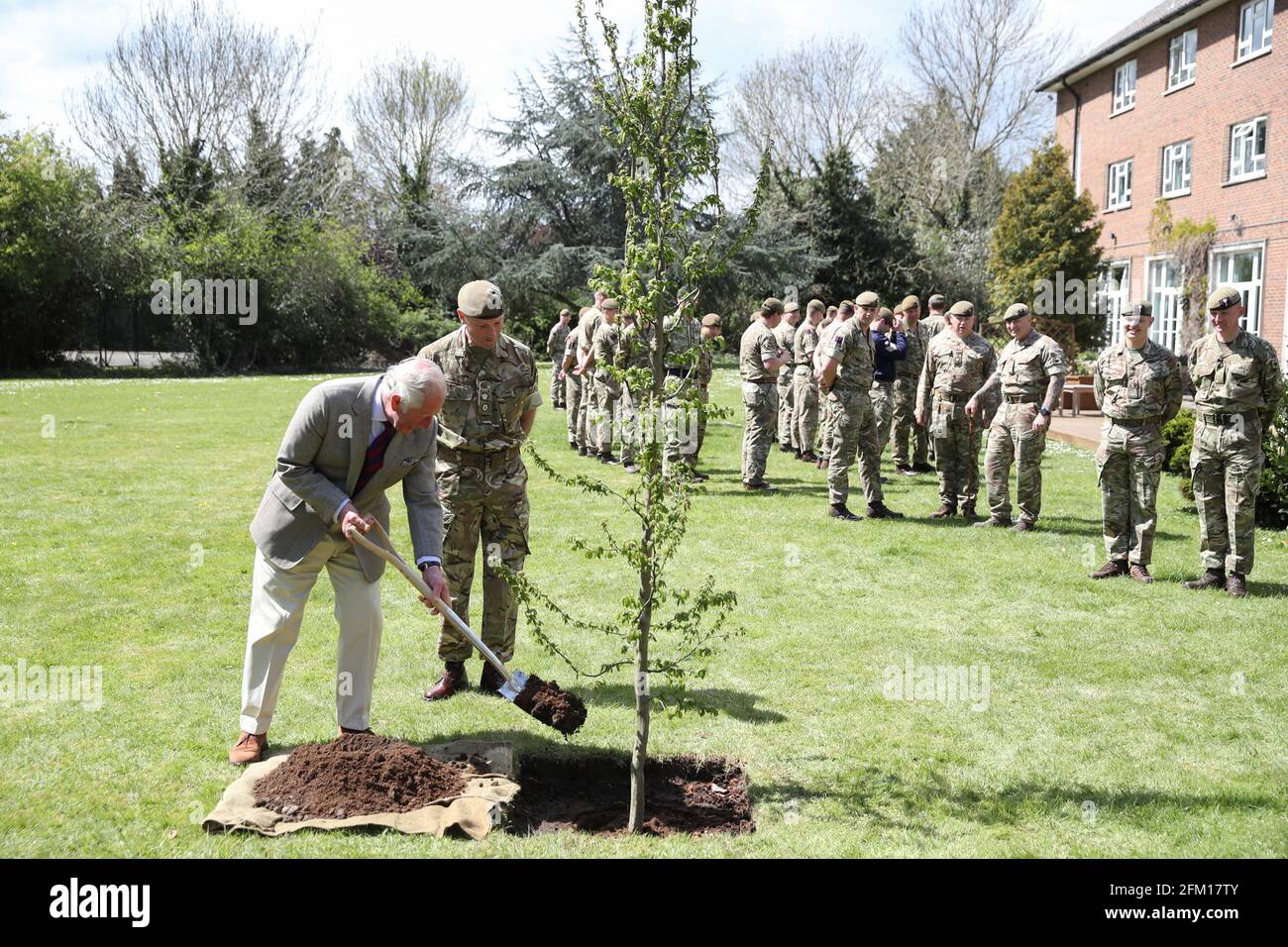 The Prince of Wales, Colonel Welsh Guards, helps plant a tree next to ...