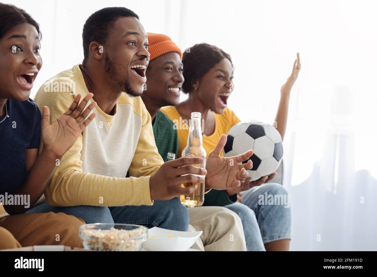 Excited black friends football fans watching game at home Stock Photo ...