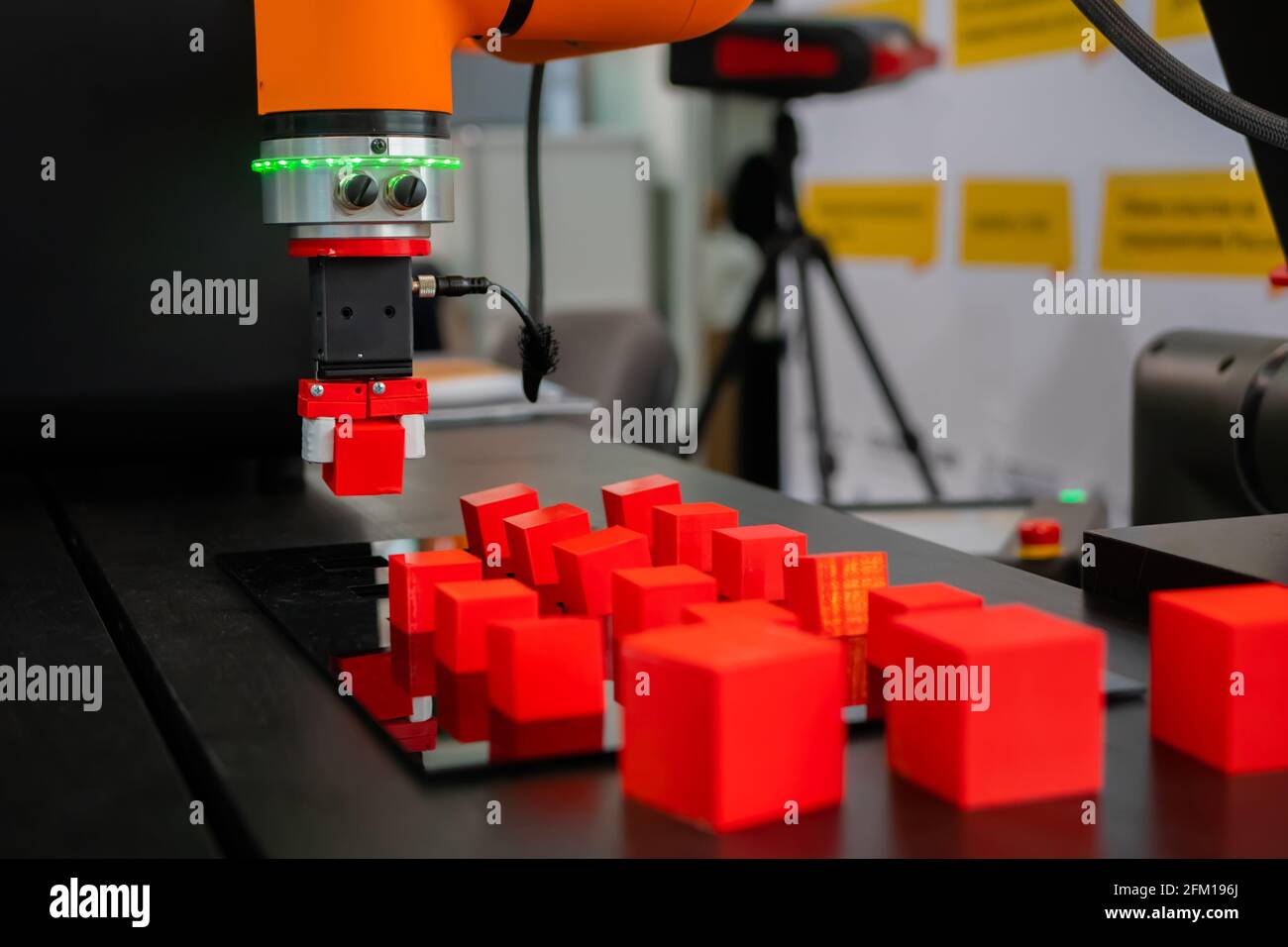 Pick and place robotic arm manipulator moving red toy blocks at robot ...