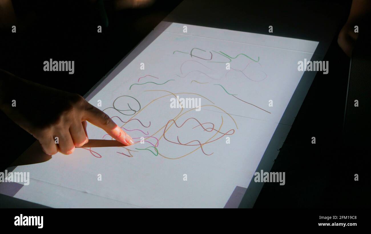 Woman using interactive touchscreen projector display for drawing Stock ...