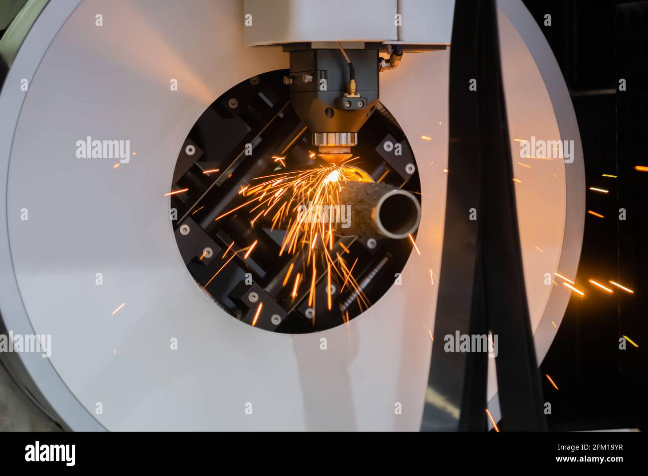 Laser cutting machine working with cylindrical metal workpiece with ...