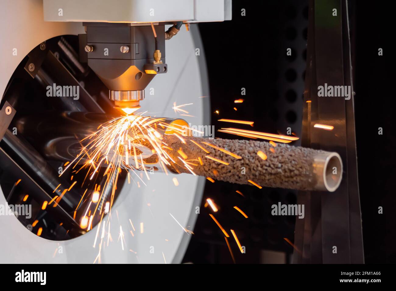 Laser cutting machine working with cylindrical metal workpiece with ...