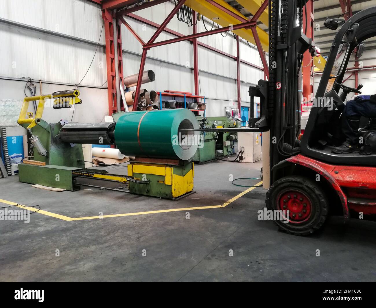 Sheet metal cutting machine with a hydraulic motor torus in a warehouse ...