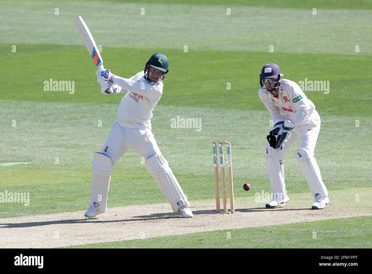 Tom Moores hits out for Notts as Robbie White looks on from behind the ...