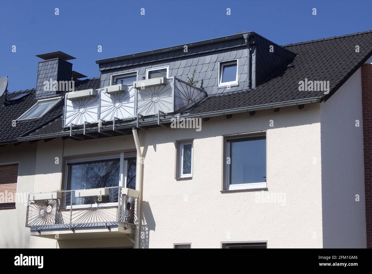 Closeup shot of balconies with sunbeams railing and dormer window with ...