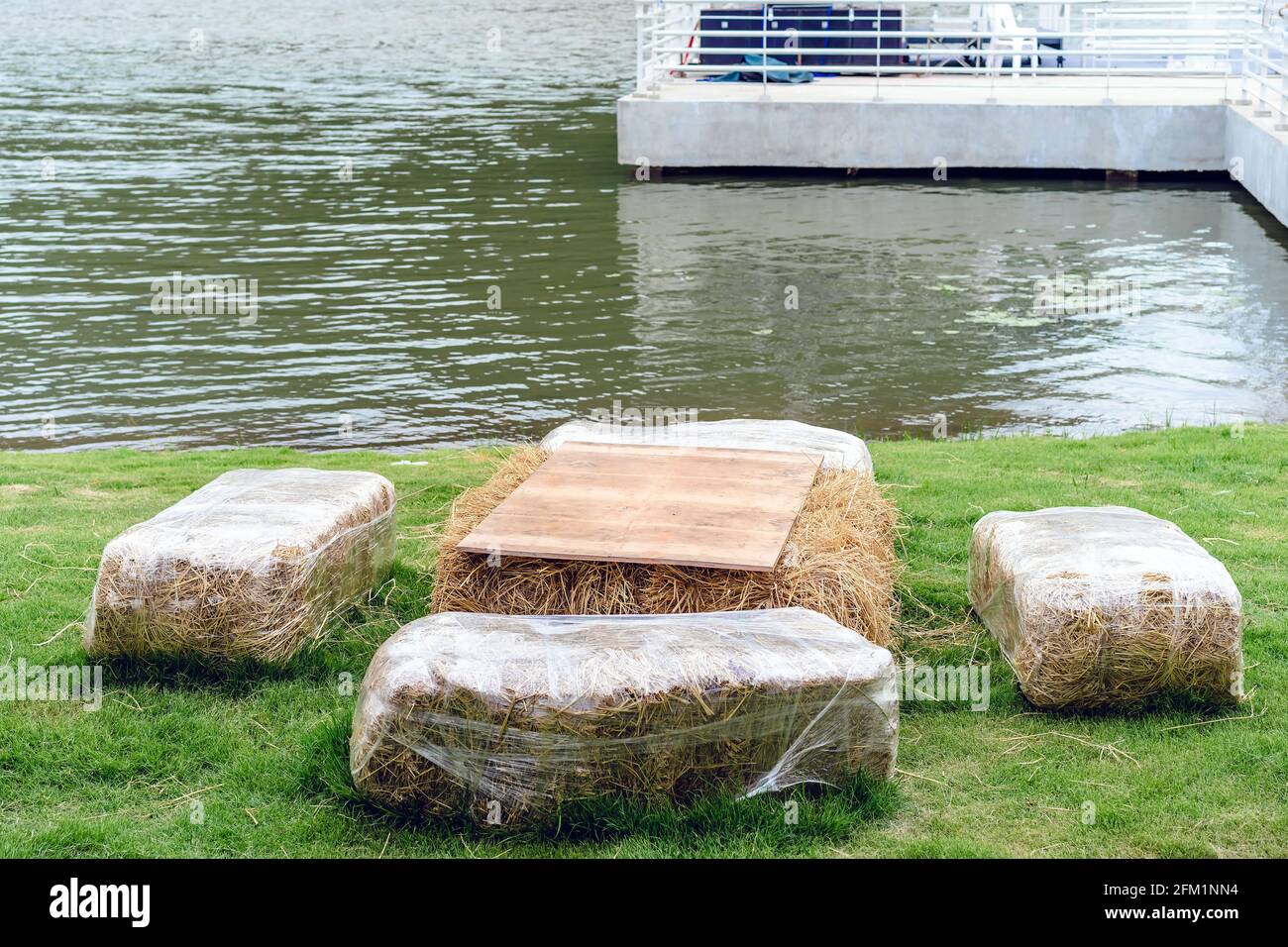 Seats and tables made from straw bales for event and party laid on lawn ...