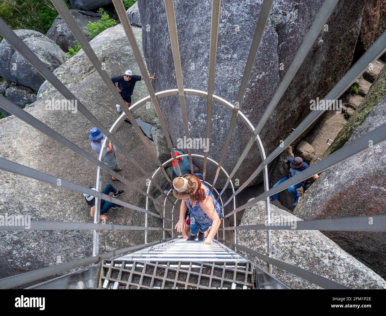 Female Caucasian tourist climbing caged ladder on Granite Skywalk at ...