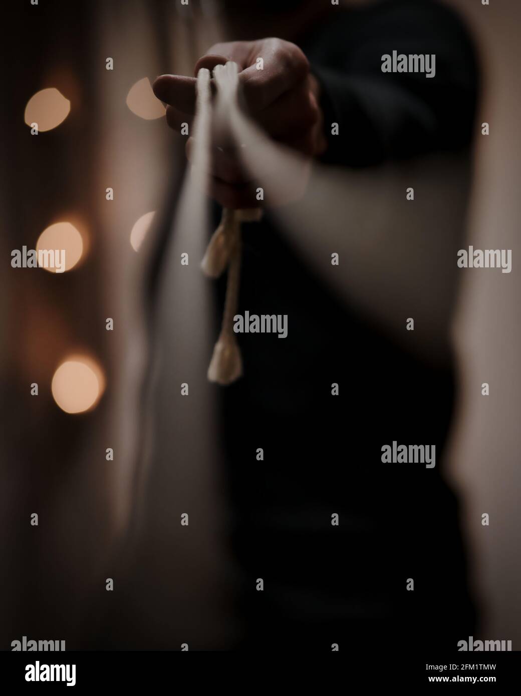 Vertical shot of a man holding ropes against a lights background Stock ...