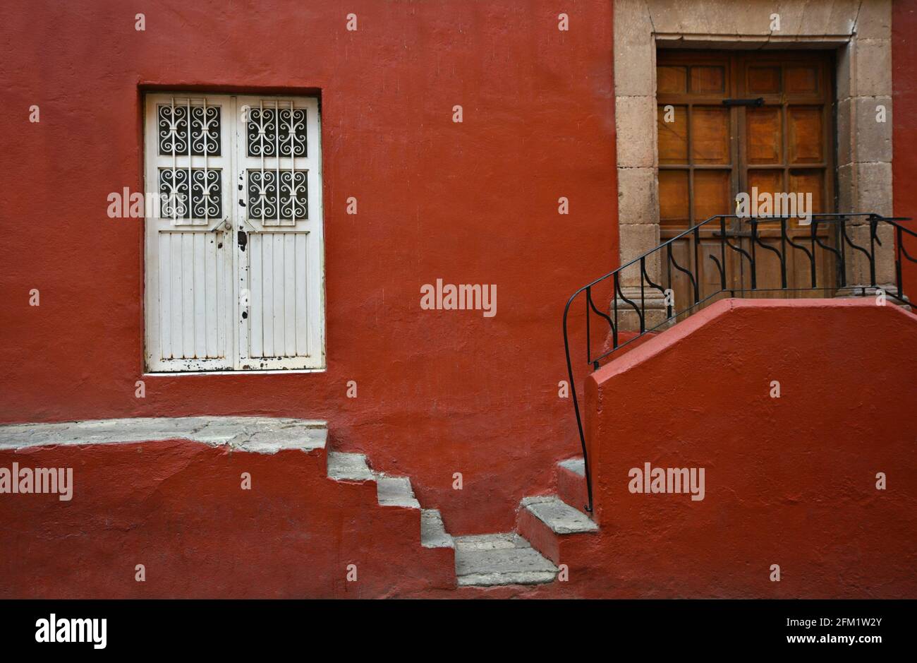 Spanish Colonial house facade with a white metal door and a handcrafted ...