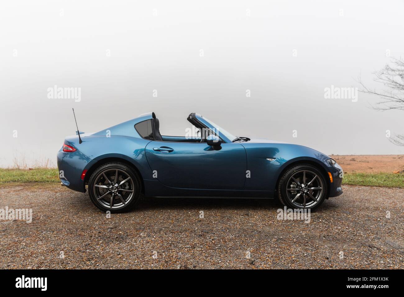 New blue 2020 Mazda MX-5 GT RF, parked (with the roof down) next to the ...