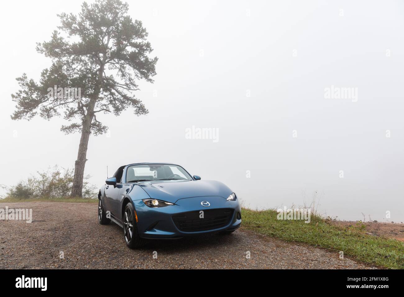 New blue 2020 Mazda MX-5 GT RF, parked (with the roof down) next to the ...