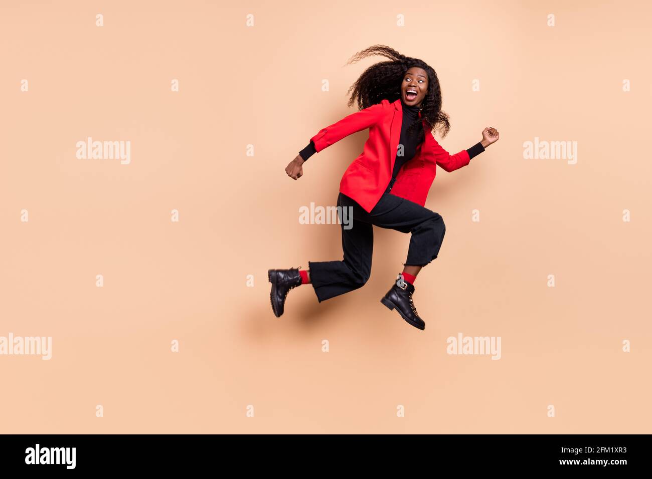 Photo of sweet cute curly dark skin woman dressed red blazer jumping ...