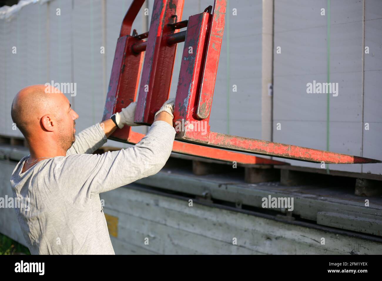 Unloading building blocks from a truck using a crane. Hydraulic ...