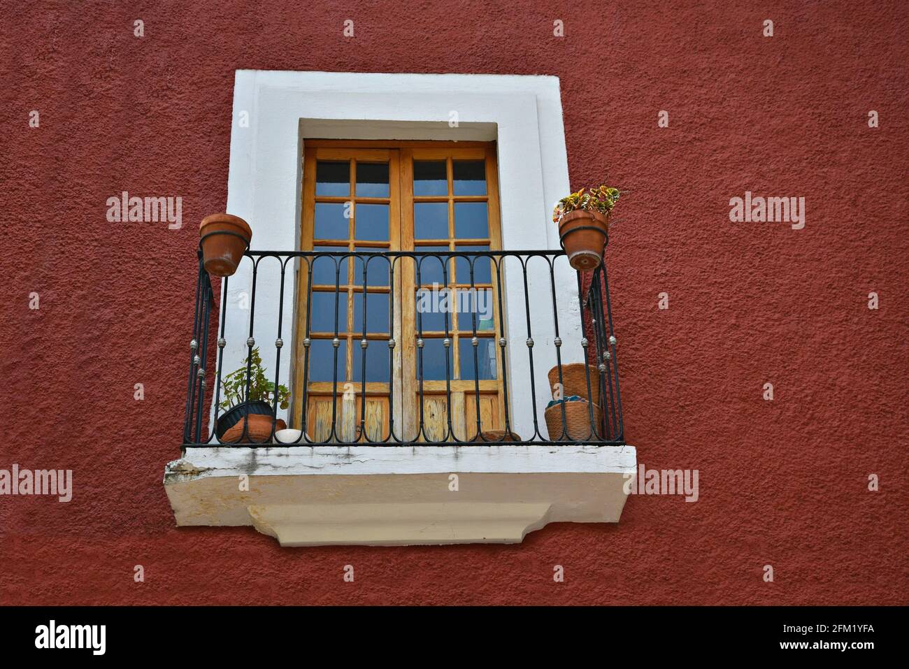 Spanish Colonial house with a Venetian red stucco wall, stone trimmed ...