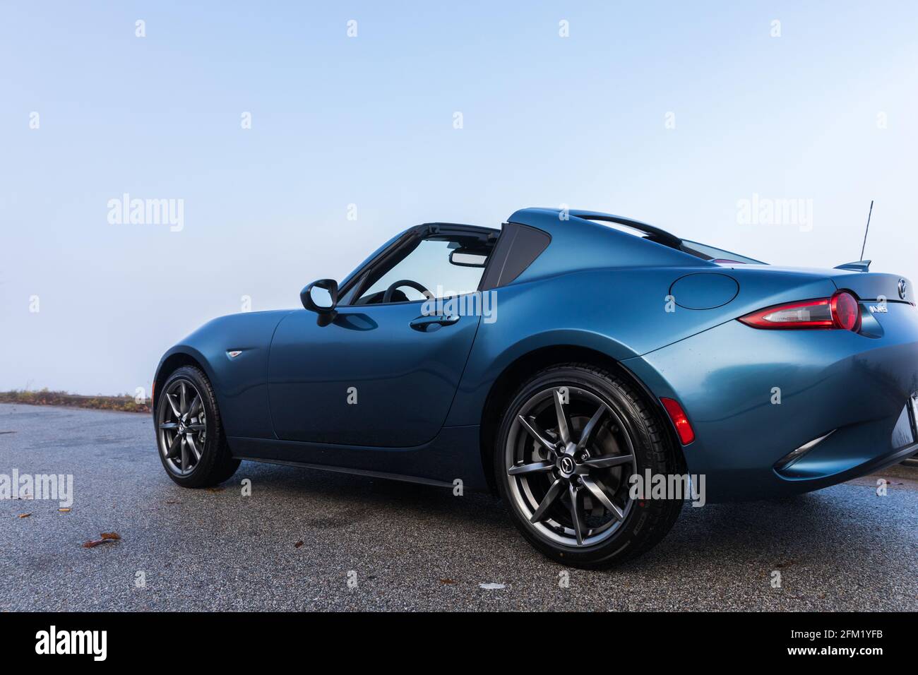New blue 2020 Mazda MX-5 GT RF, parked (with the roof down) next to the ...
