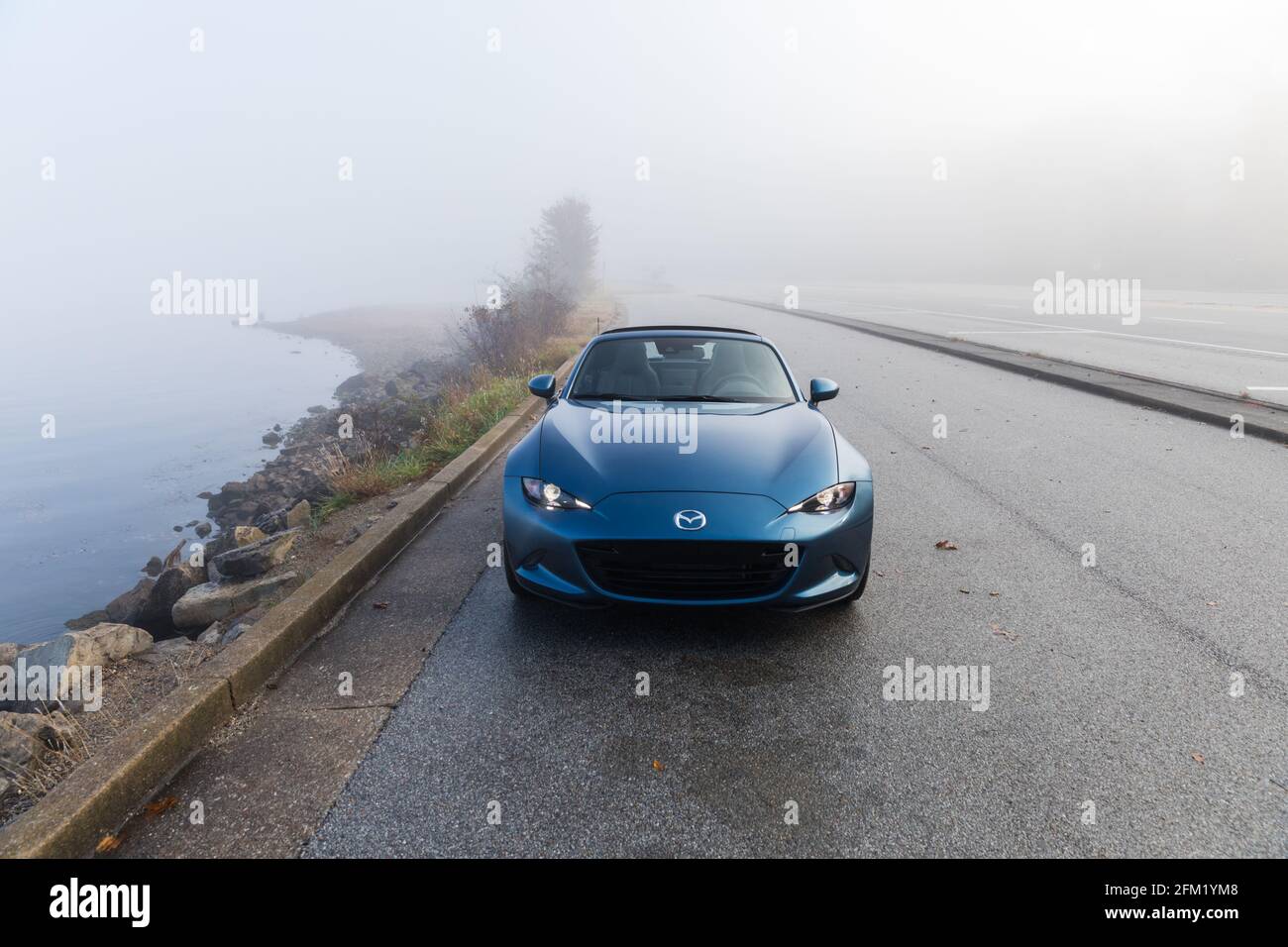 New blue 2020 Mazda MX-5 GT RF, parked (with the roof down) next to the ...