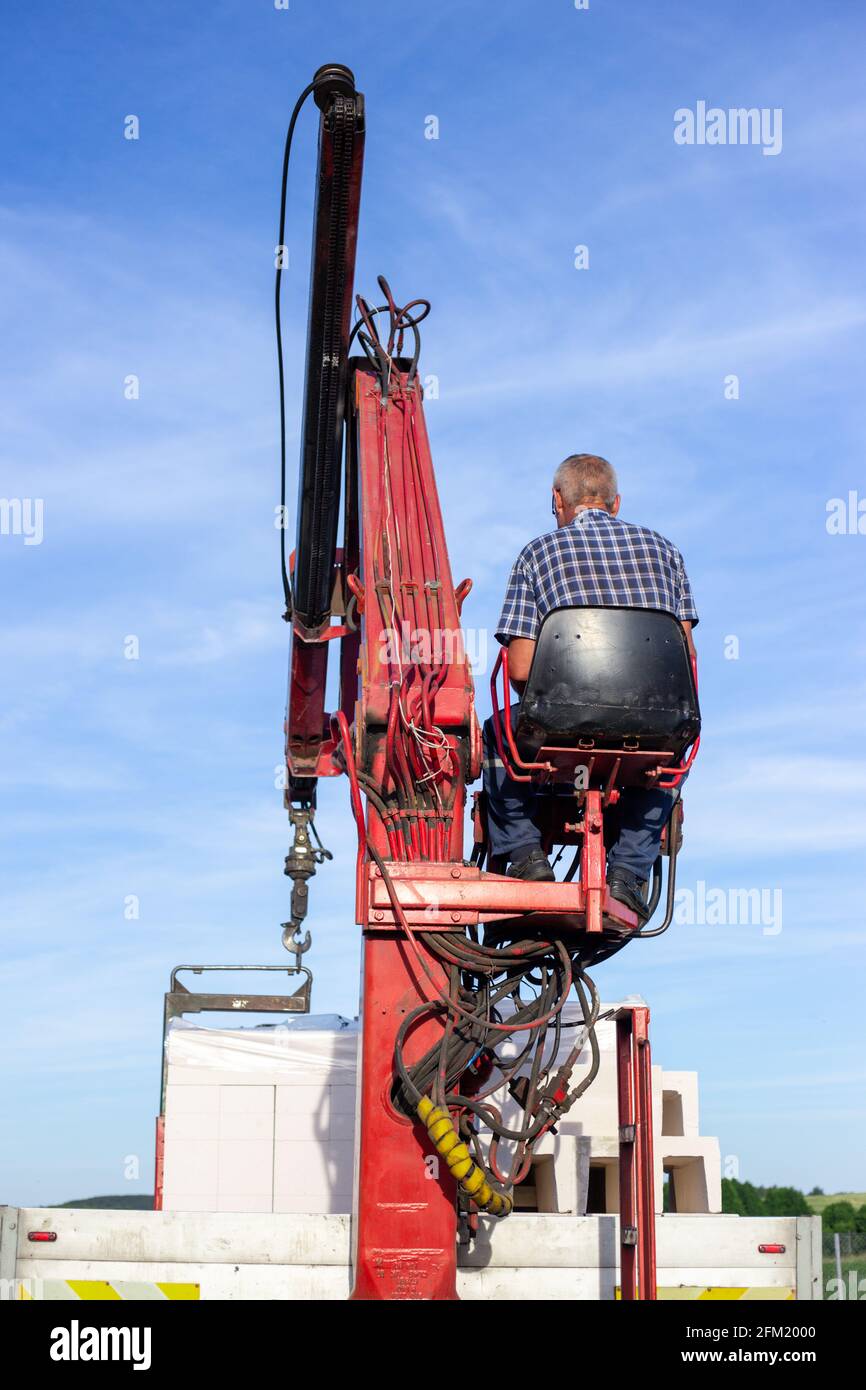 Unloading building blocks from a truck using a crane. Hydraulic ...