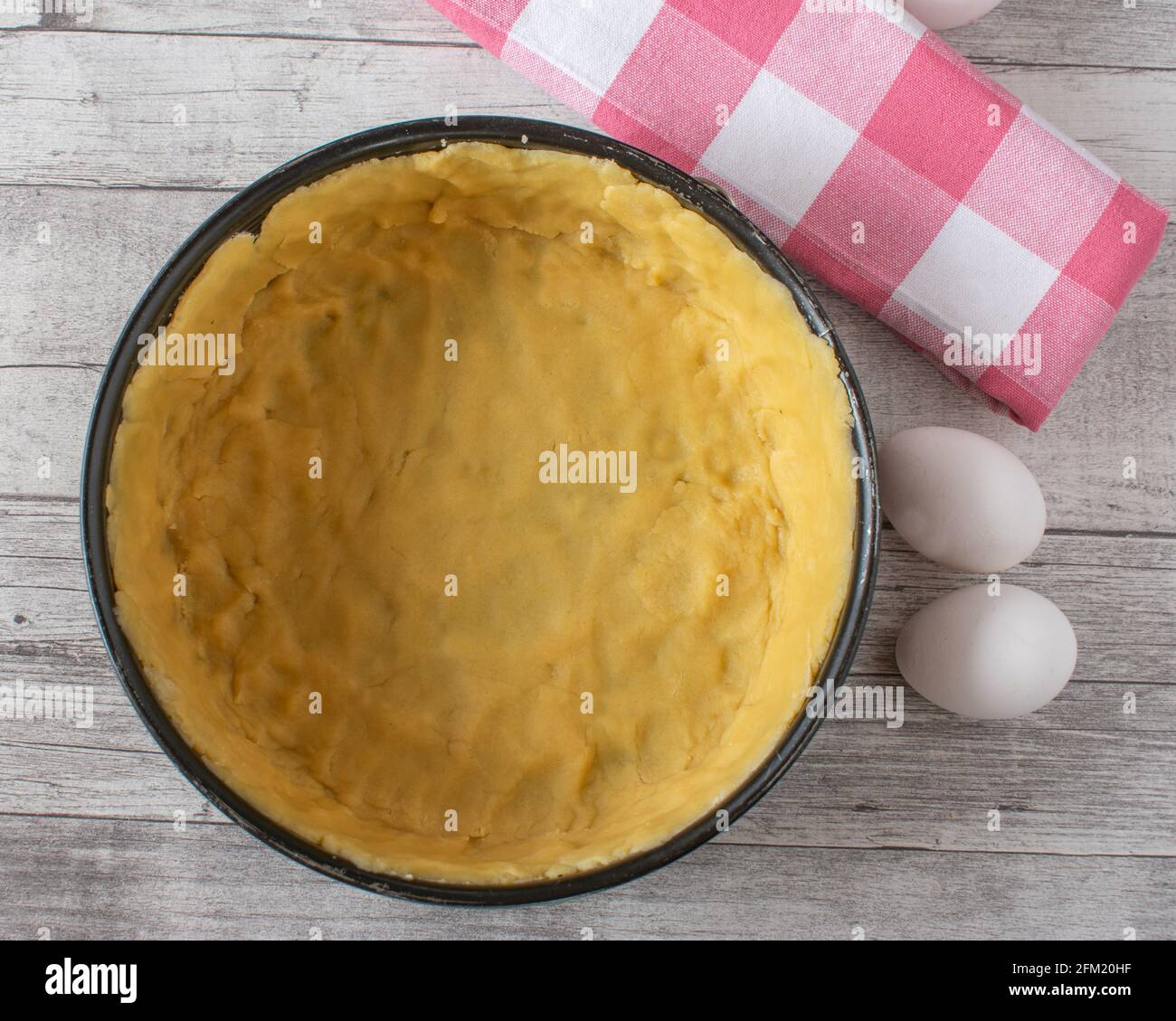 homemade fresh dough for making a cake base in a round baking pan on ...