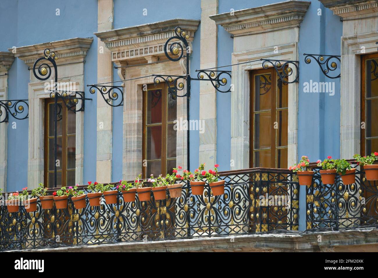 Spanish Colonial building facade with a light blue stucco wall, stone ...