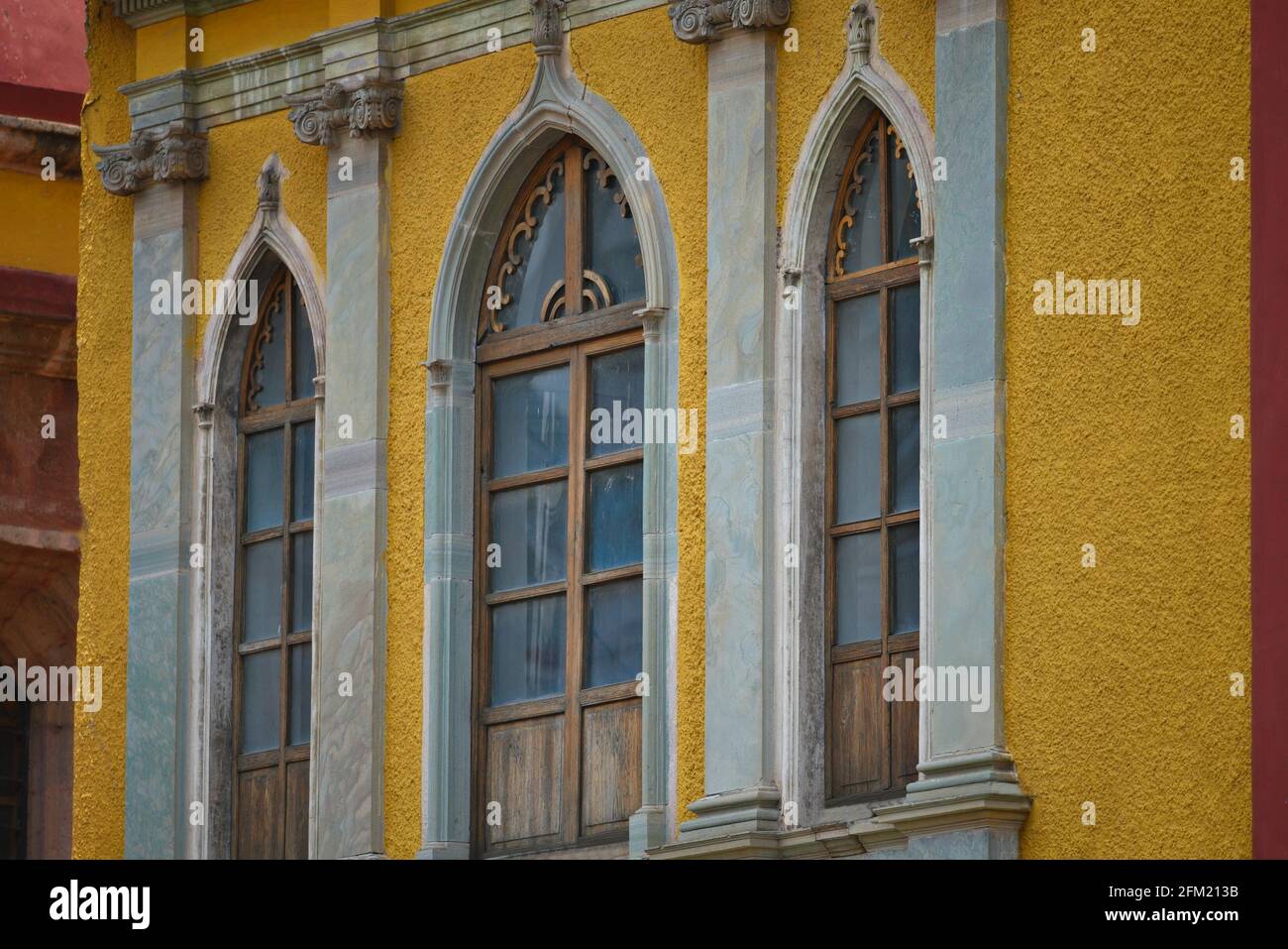 Baroque style facade with an ochre wall and stone trimmed windows of ...