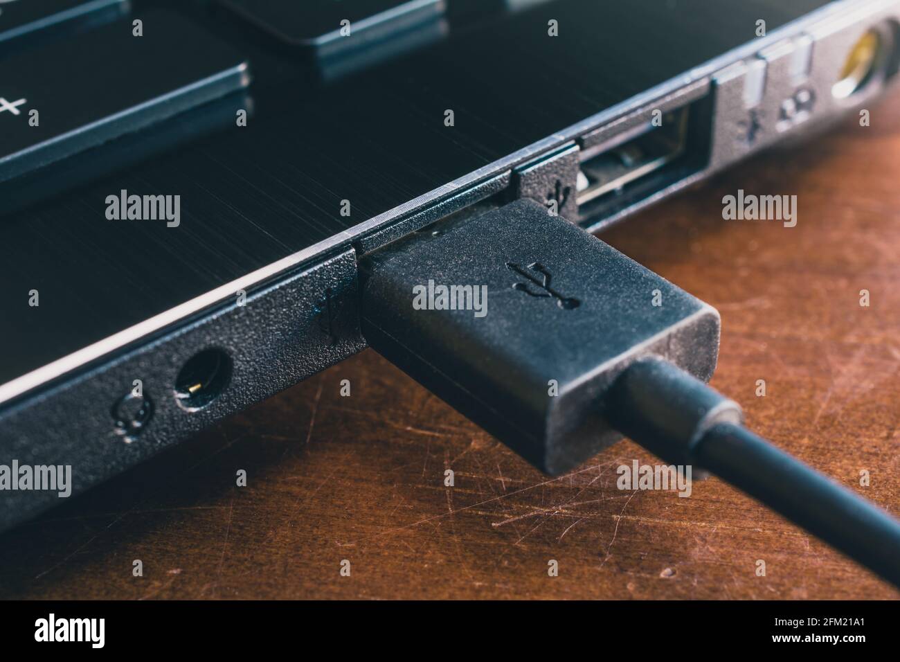 Black USB Cable Plugged In The USB Port Of A Black Notebook Stock Photo ...