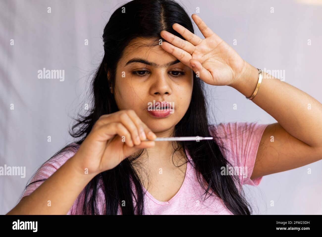 Selective focus on an Indian Asian woman checking fever with a ...