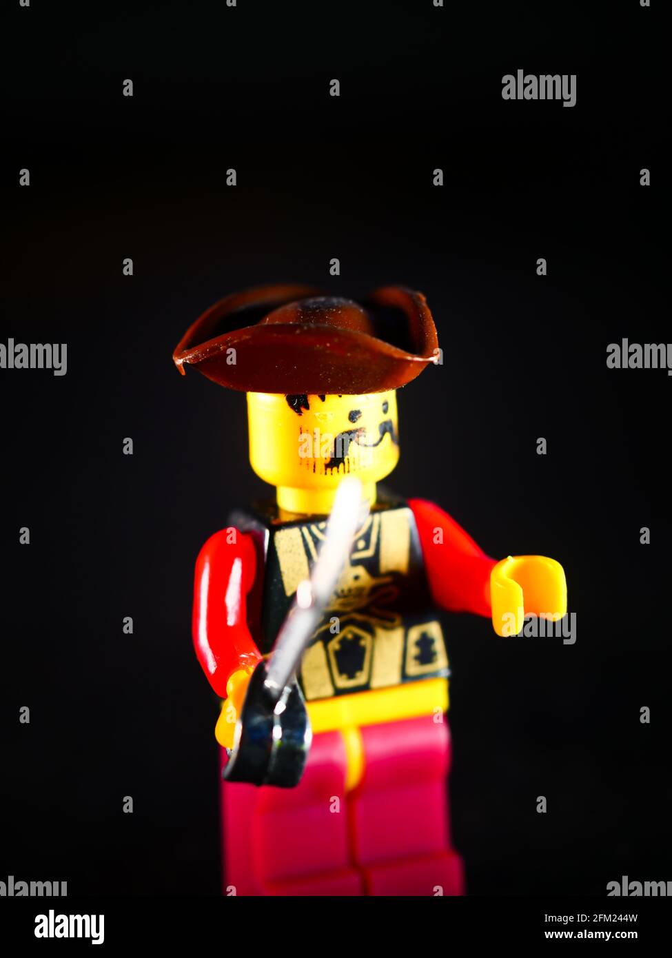 Closeup shot of a cowboy with a mustache holding a sword, a small ...