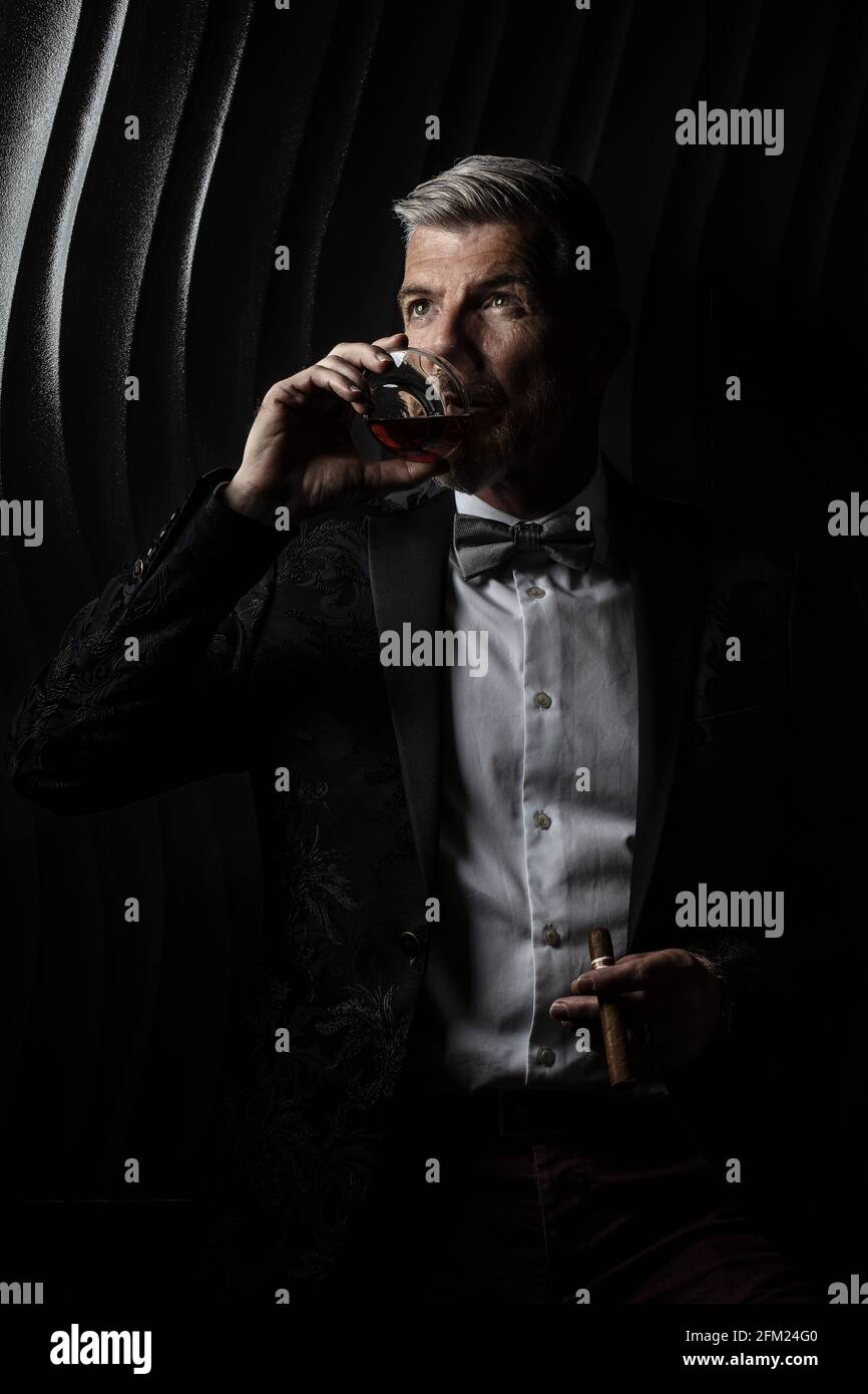 Portrait of a gentleman drinking a glass of alcohol Stock Photo - Alamy