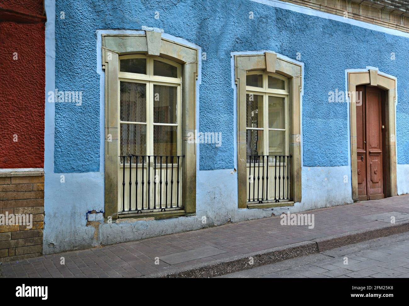 Spanish Colonial house facade with a Venetian stucco wall, symmetrical ...