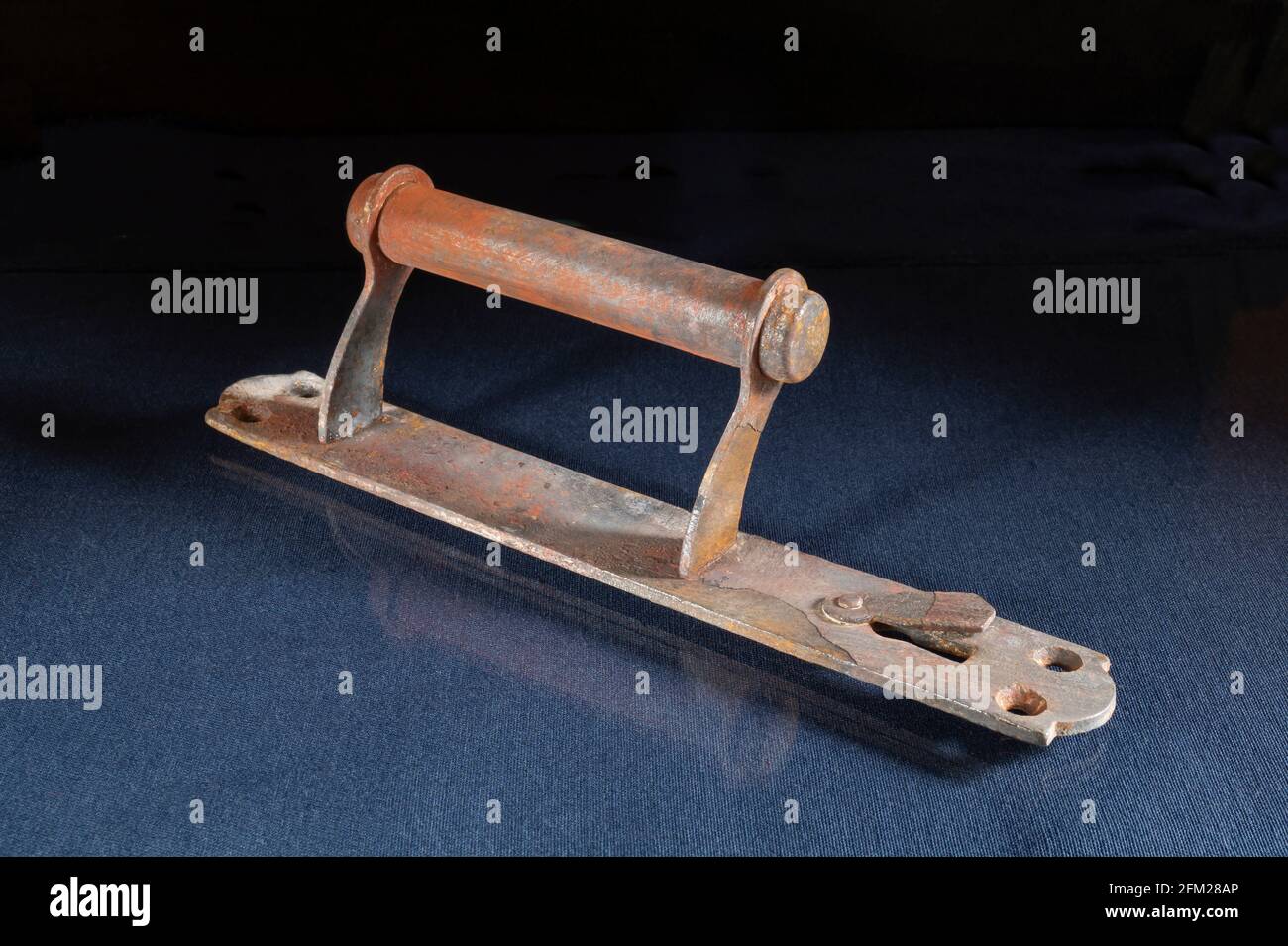 The rusty doorknob is on the table. An iron object on a black ...