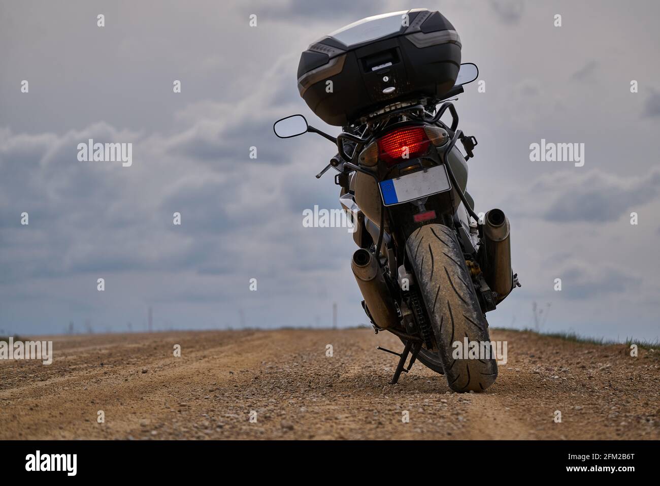 Enduro motorcycle traveler alone under a blue sky with white clouds ...
