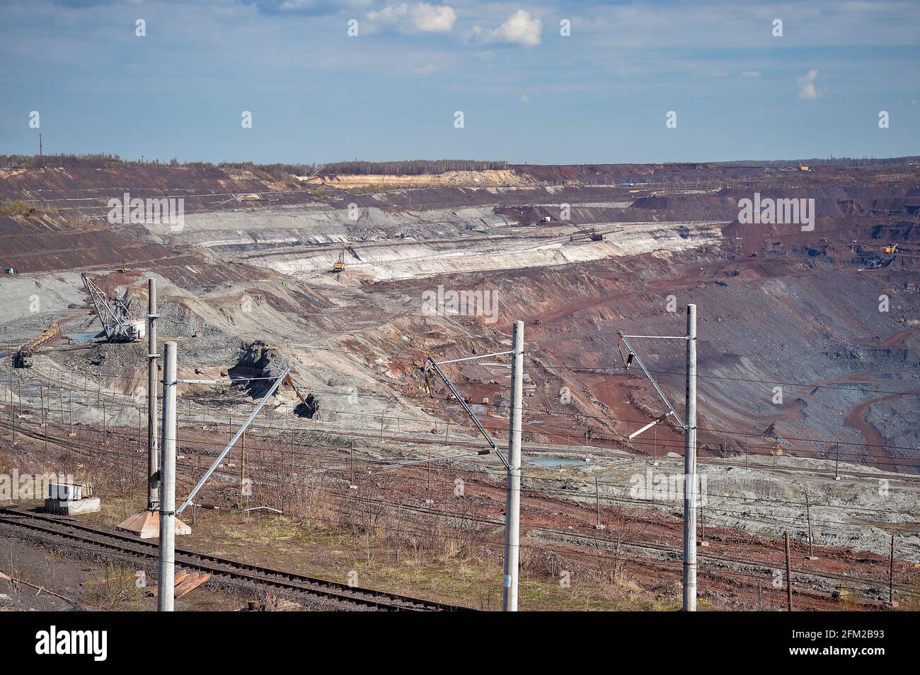 A power line, a walking excavator, a railway train against the ...