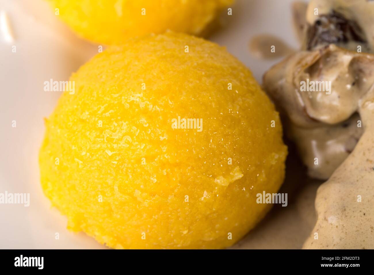 Traditional maize porridge with pork meat covered with mushroom sauce ...