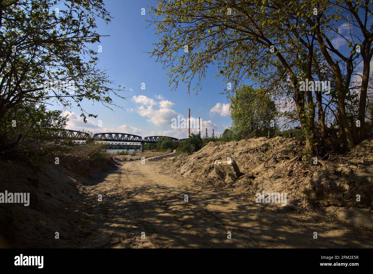 Sand road bordered by trees at the entrance of a park in the italian ...