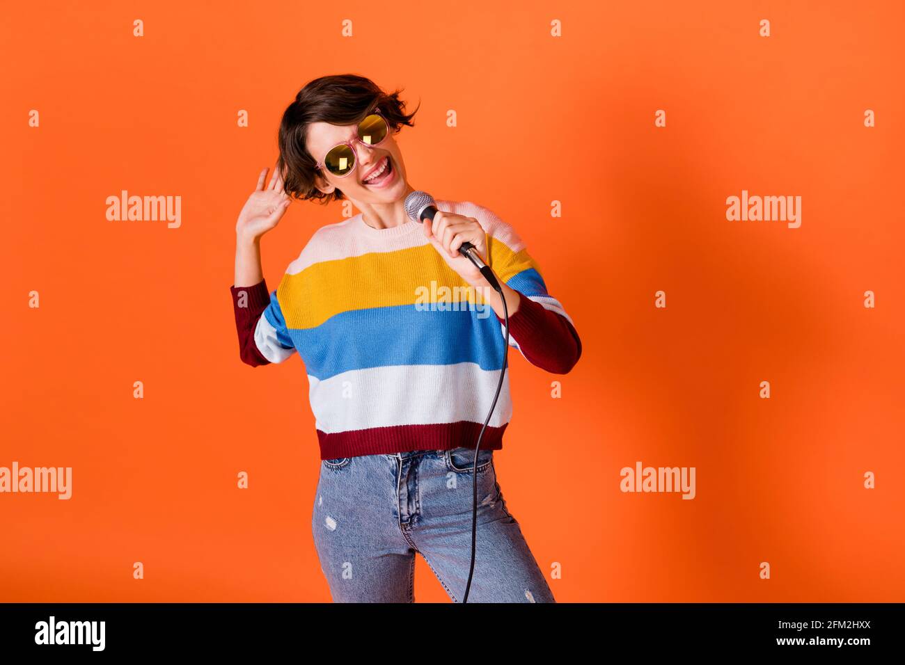 Portrait of ecstatic funky lady hand hold mic open mouth singing loud ...