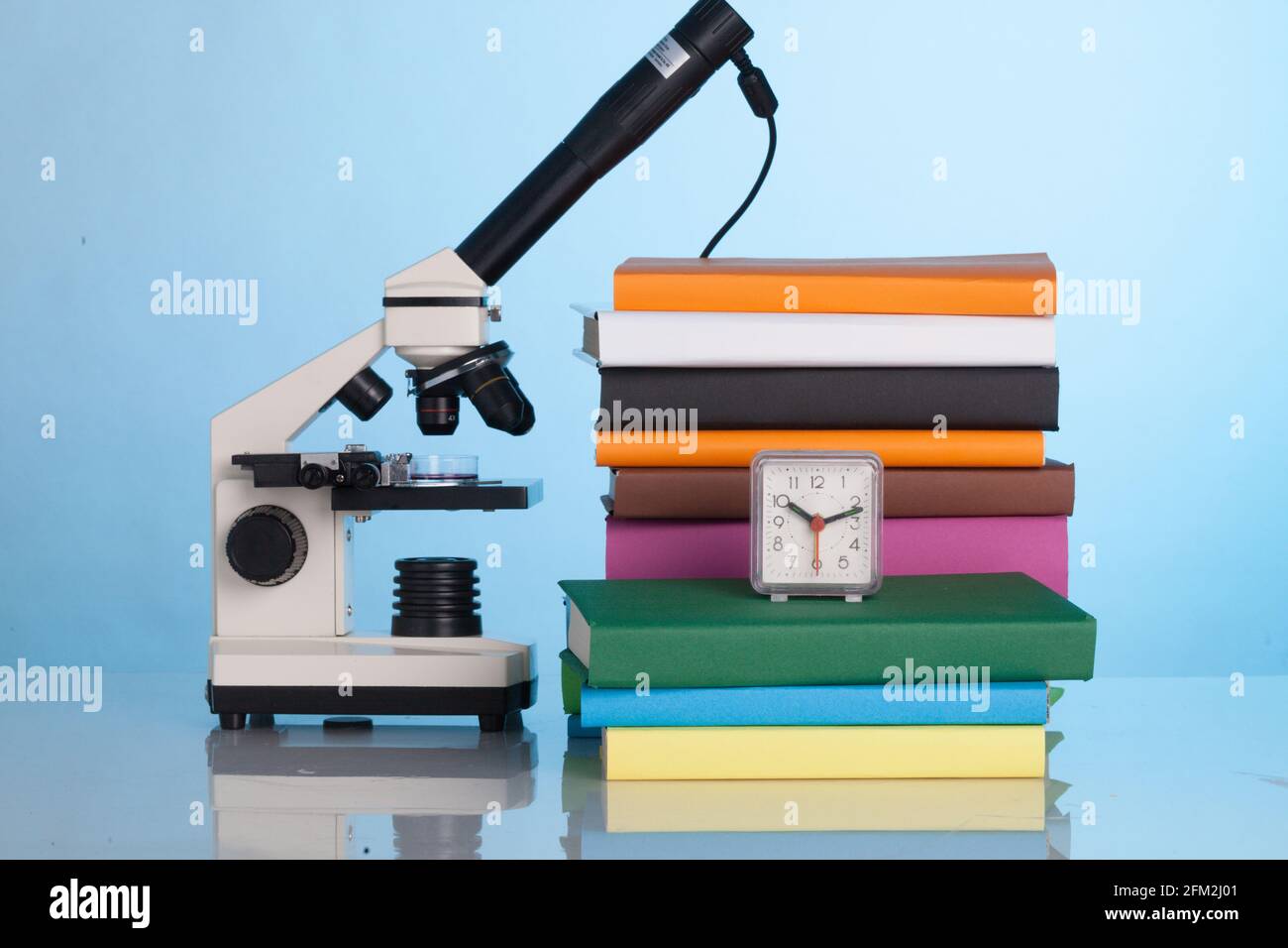Books and a microscope on the desk of the student Stock Photo - Alamy