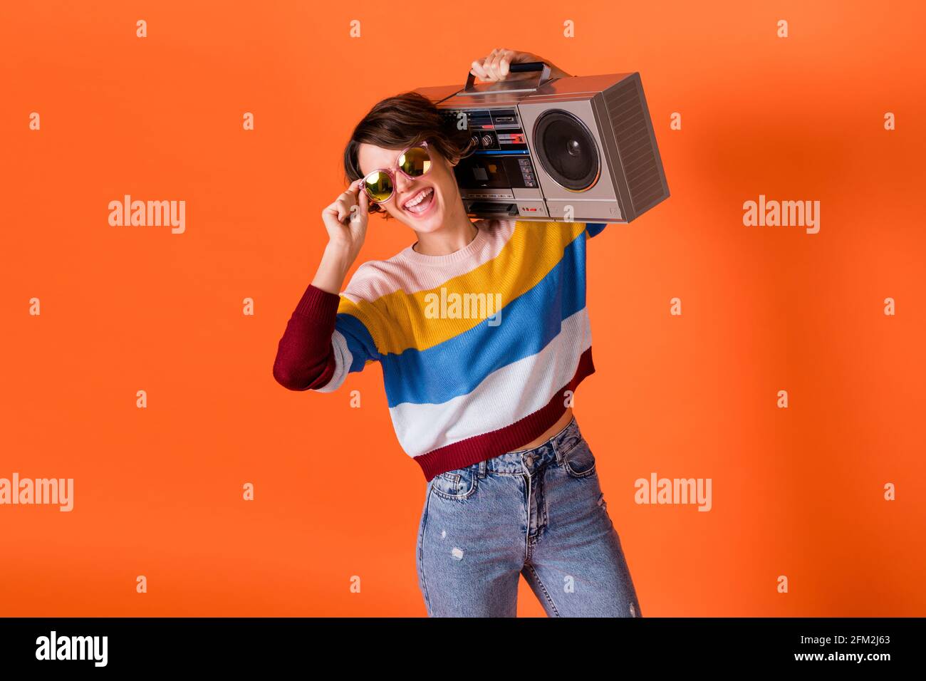 Photo of positive carefree lady hold boom box on shoulder touch ...