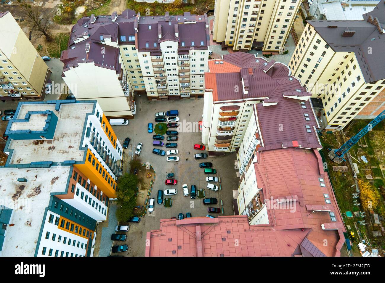 Aerial view of parked cars on parking lot between high apartment ...