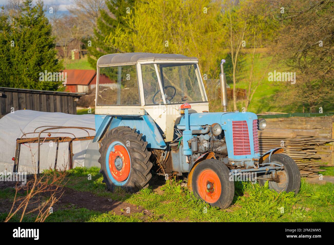 an old blue tractor in village Stock Photo - Alamy