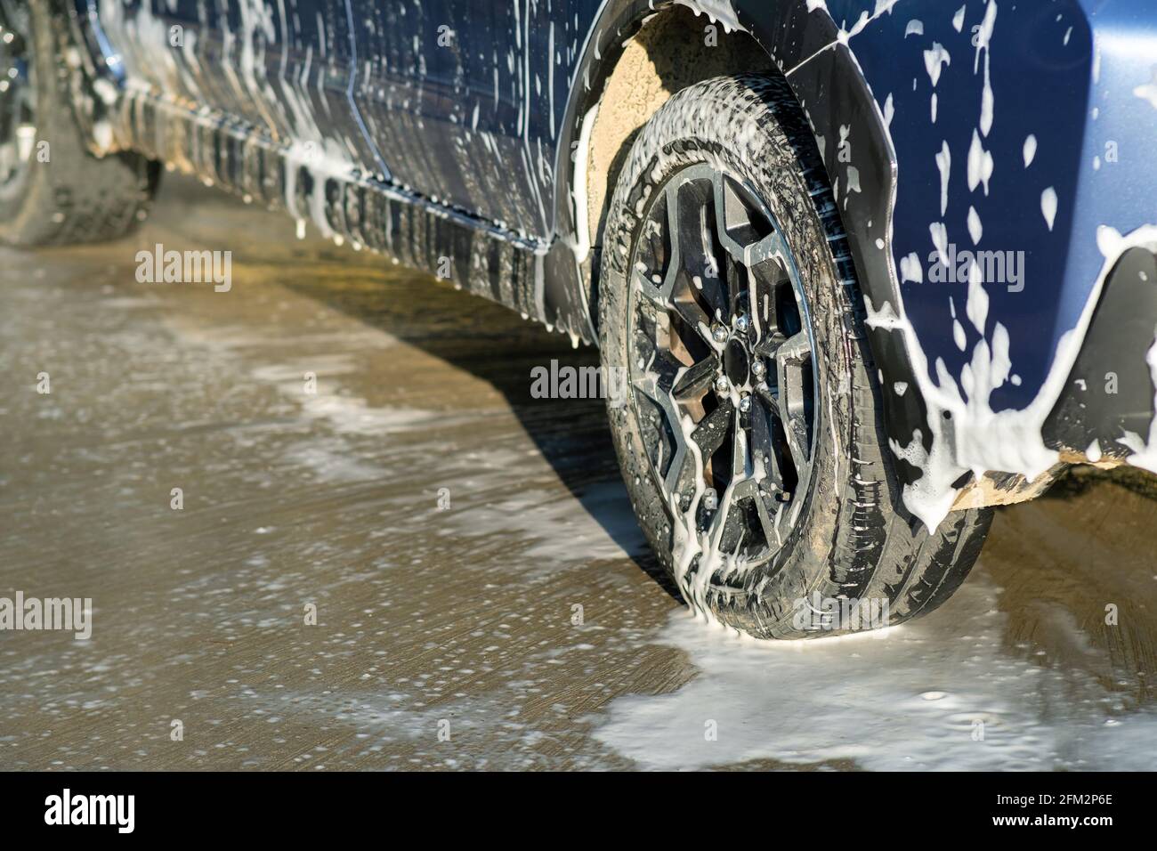 Closeup of male driver washing his car with contactless high pressure ...