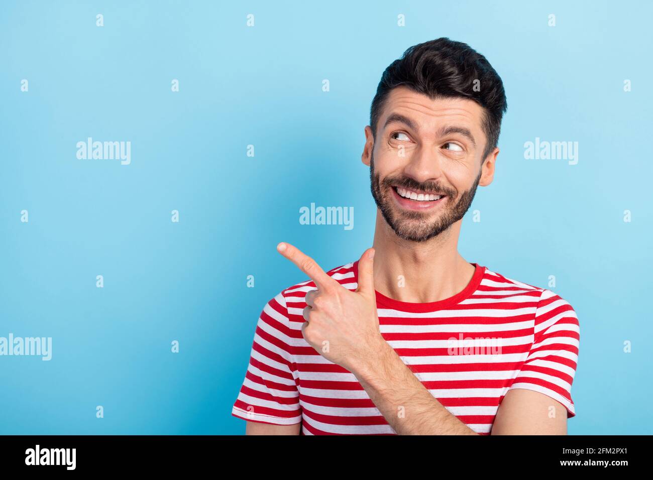 Photo of handsome dreamy young man point finger empty space look ...