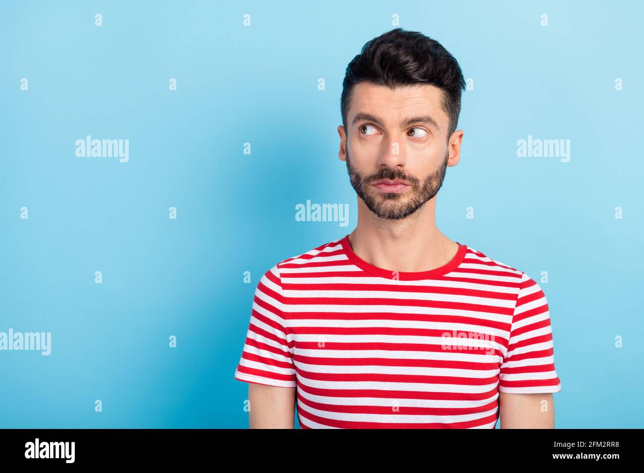 Photo of funny suspicious young guy wear red outfit looking empty space ...