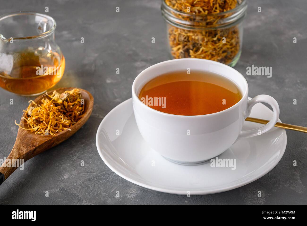 Calendula tea in a white cup. Herbal tea with dried marigold flowers ...