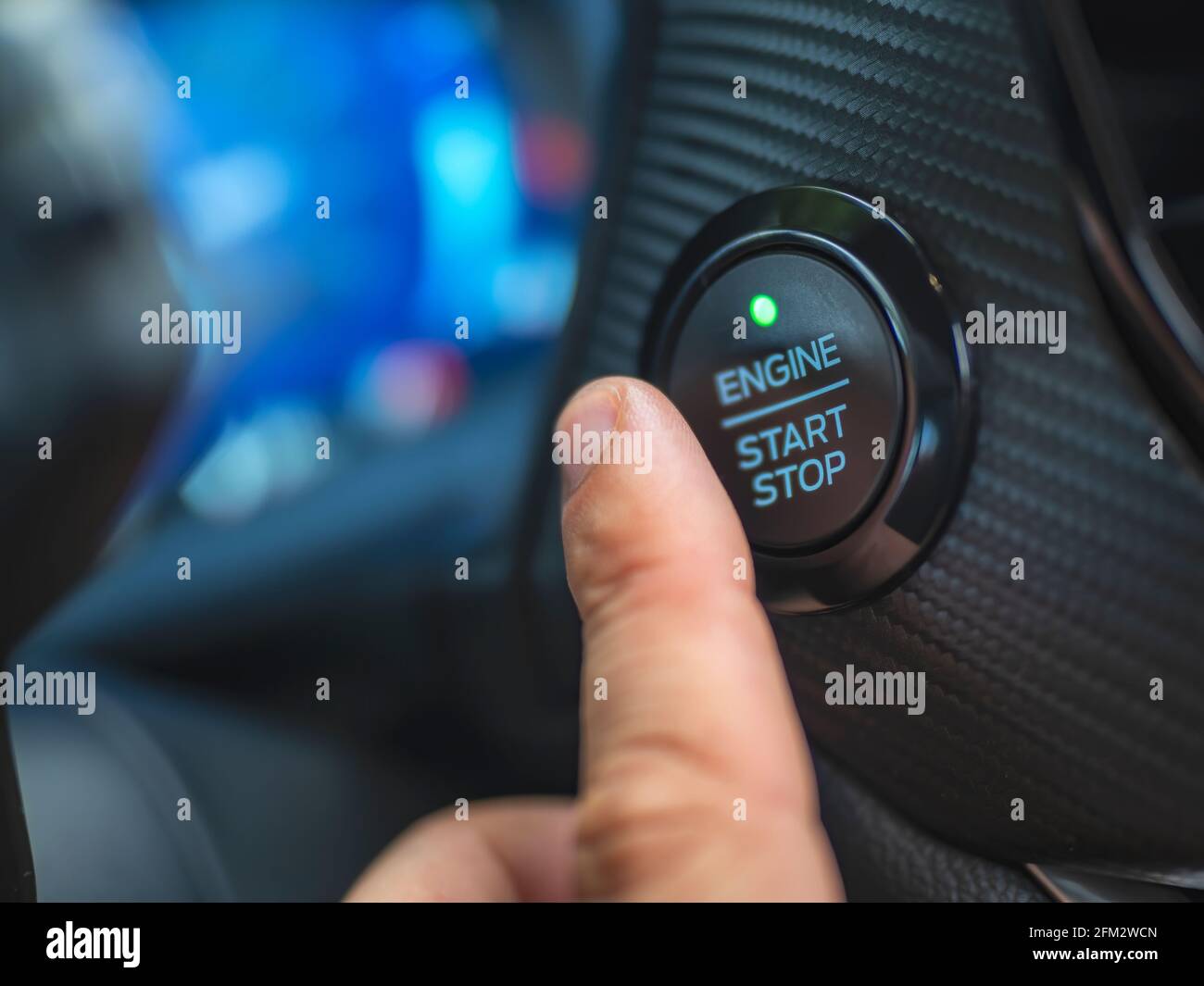 The driver's finger is pressing the car start button. Concept of ...