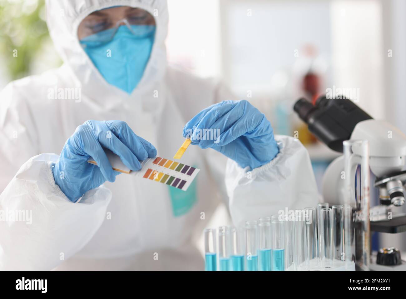 Researcher in protective suit holds chemical reagents of samples Stock ...