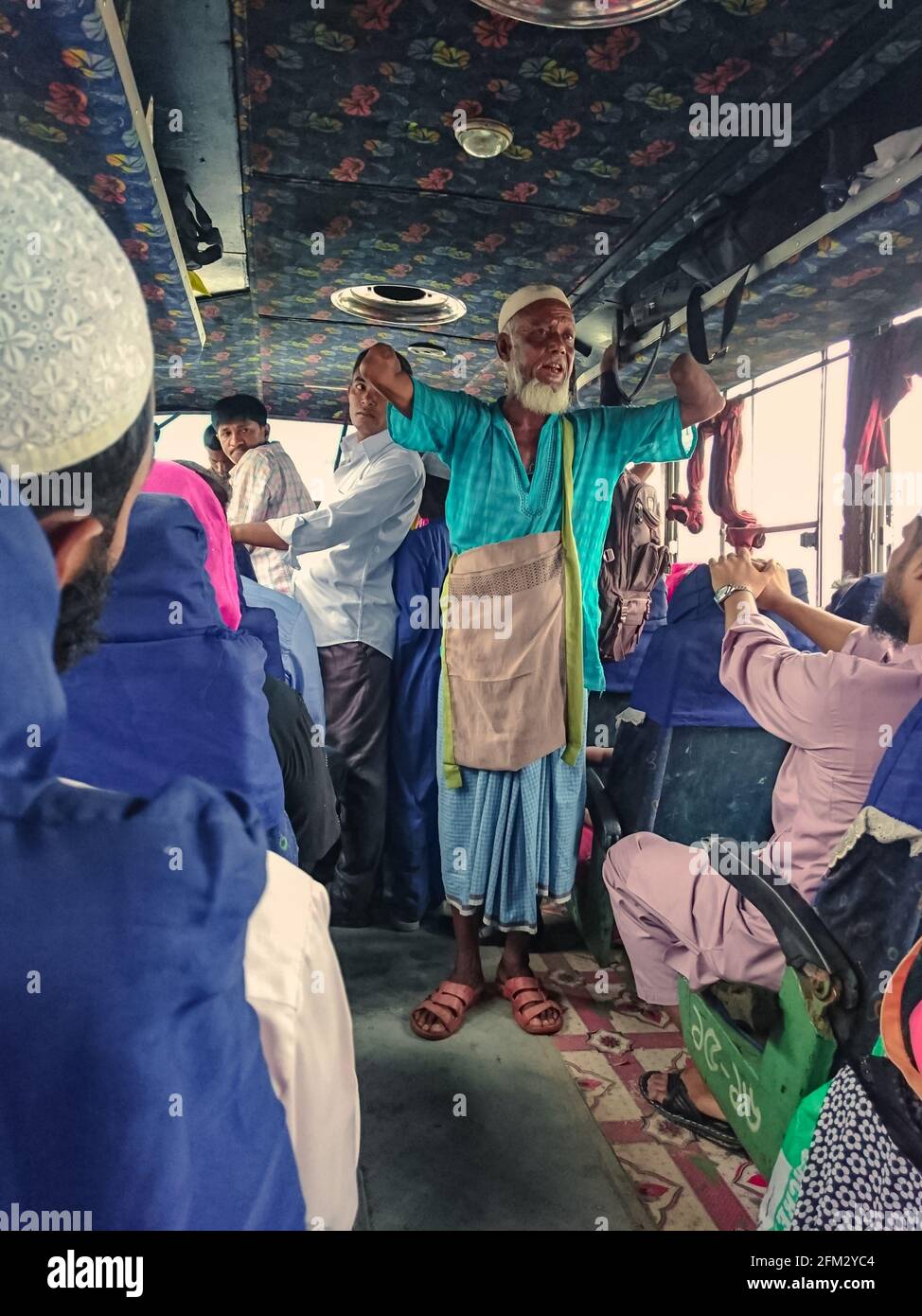 a beggar asking help in a bus Stock Photo - Alamy