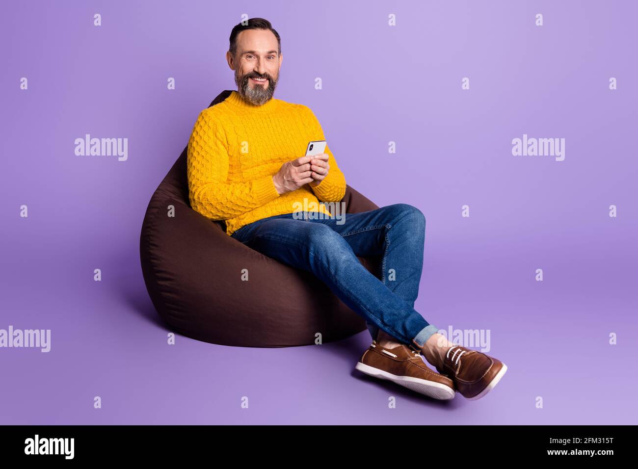 Full body profile portrait of positive person sitting big soft chair ...