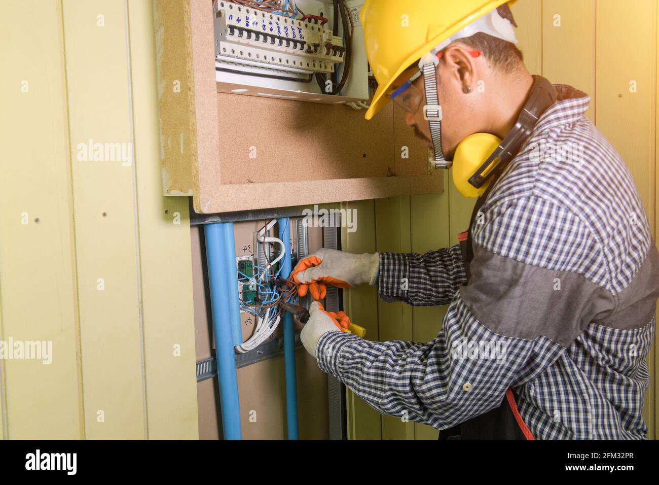 Electrician installing an electrical control panel in a building ...
