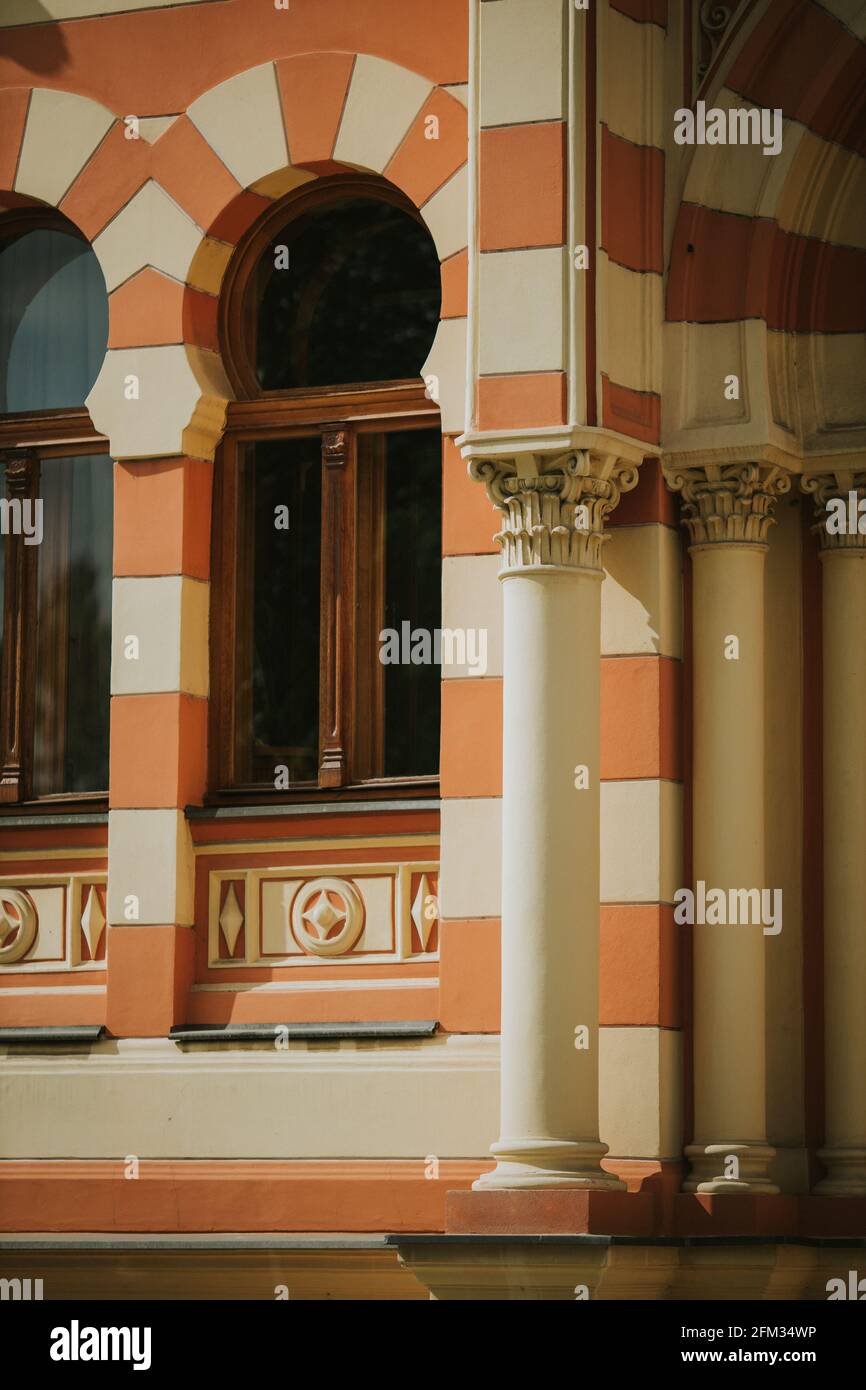 Old white and orange stone building with columns Stock Photo - Alamy
