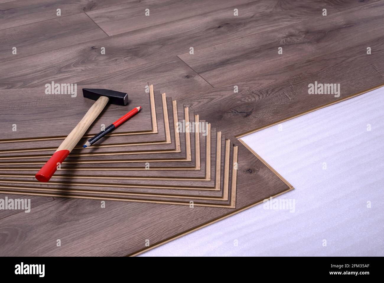 Hammer and pencil on laminate panels, carpenter tools for laying ...